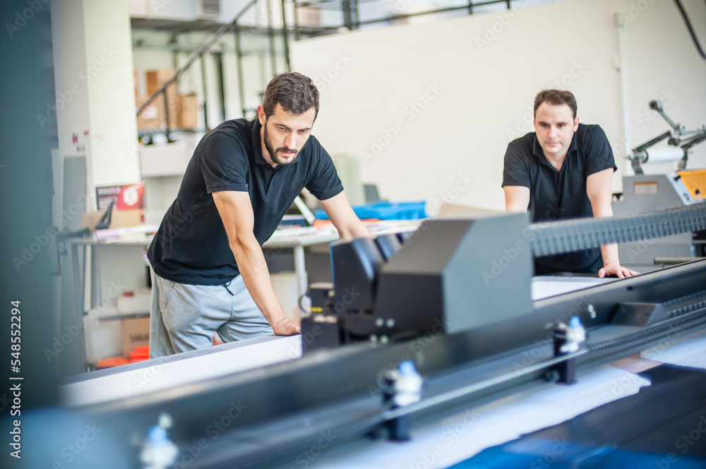 Professional worker printmaker technician operator works in printing ...