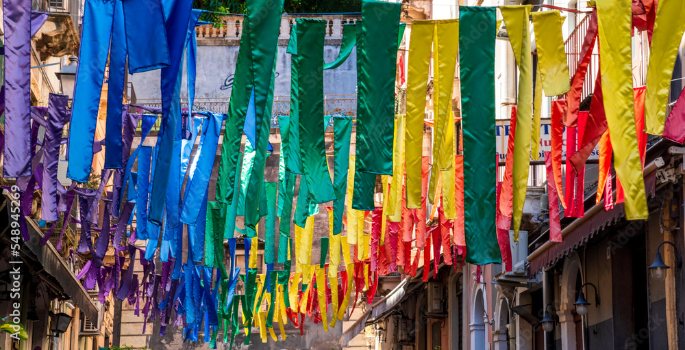 european street, decorated with hanged colorful ribbons in lgbt flag ...