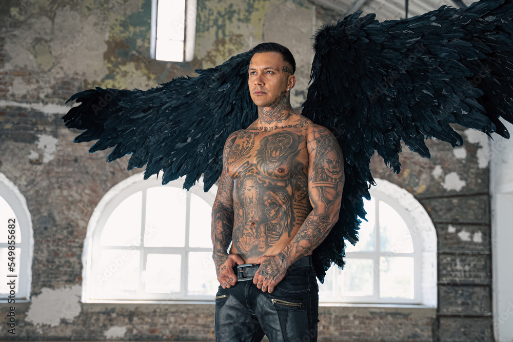 angel man with black wings, stand posing at camera. man fall from ...
