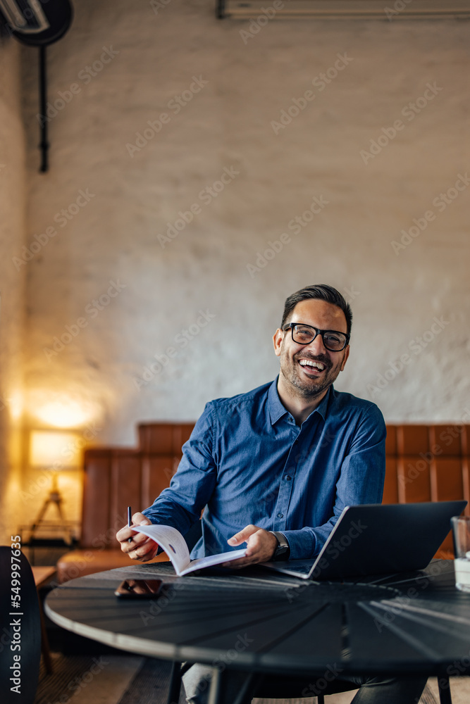 Stockfoto Smiling male being at the office, opening his notebook, using ...