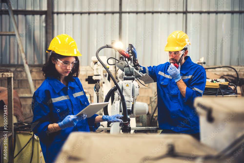 Two engineers mechanic using computer controller Robotic arm for ...