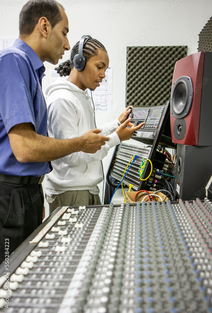 Music Students: Studio Session. A budding music producer being ...