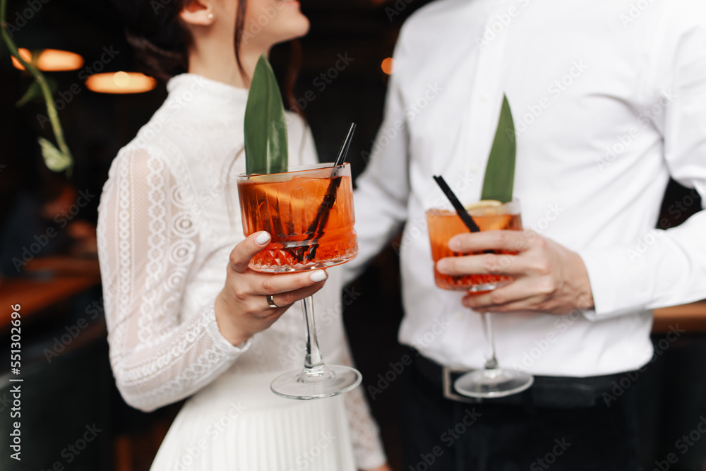 hands of woman and man are clinking, cheers with glasses of Spritz ...