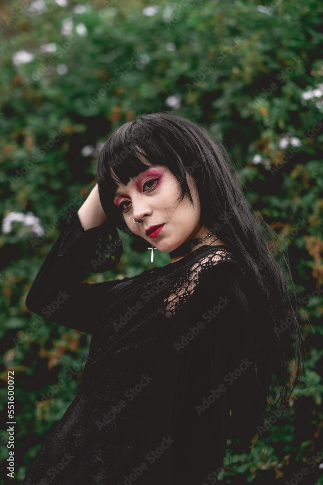 Young and skinny hispanic goth girl with black dress and red makeup ...