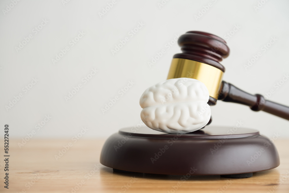 Brain and hammer judge gavel on wooden table in courtroom with white ...