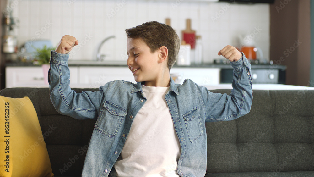 Little boy shows his arm muscles to the camera.Portrait of little boy ...