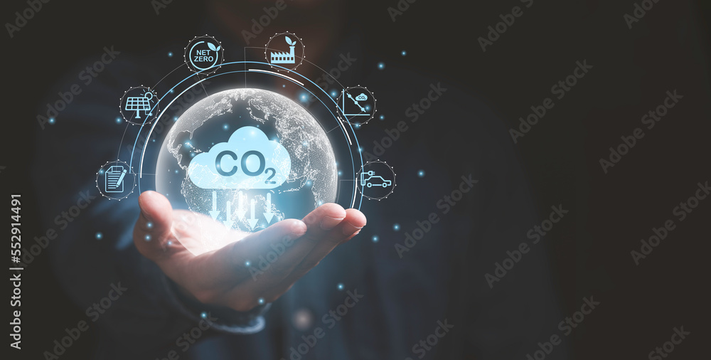 Hand holding CO2 reducing icon with virtual world for decrease carbon dioxide emission ,carbon ...