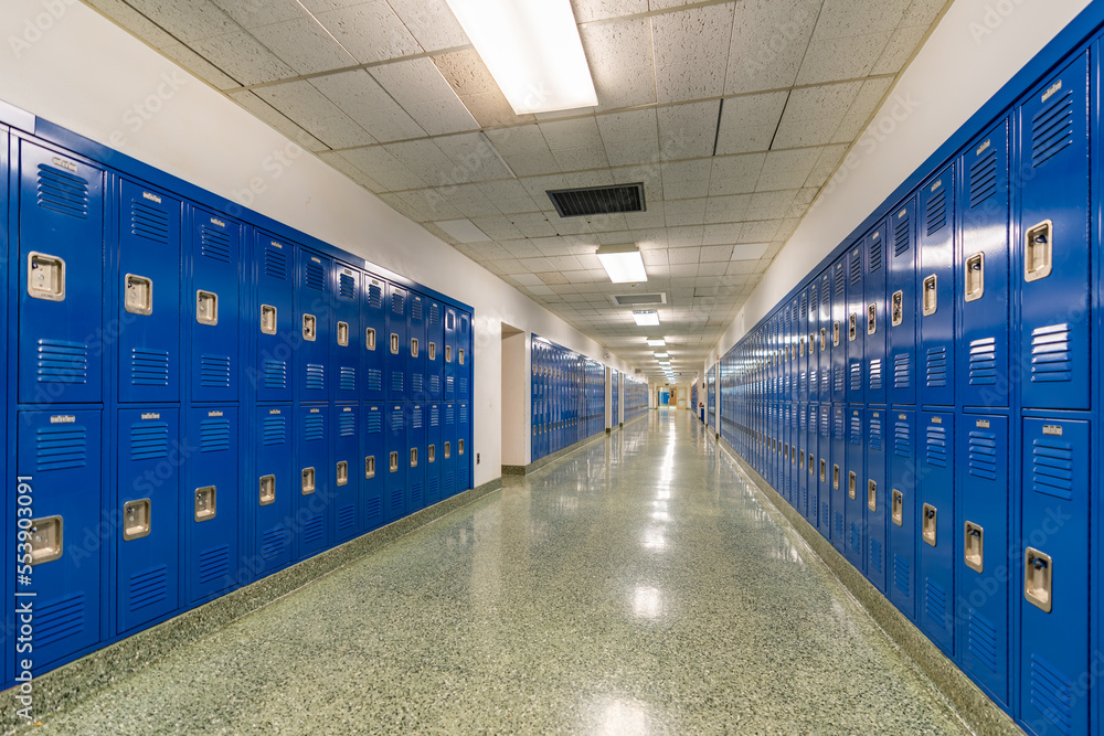 Typical, nondescript USA empty school hallway with royal blue metal ...