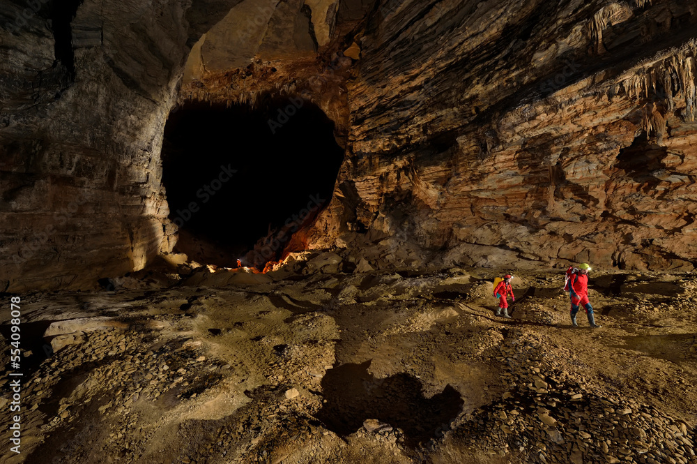 Cave explorers walk through a section of cave in San Wang Dong called ...