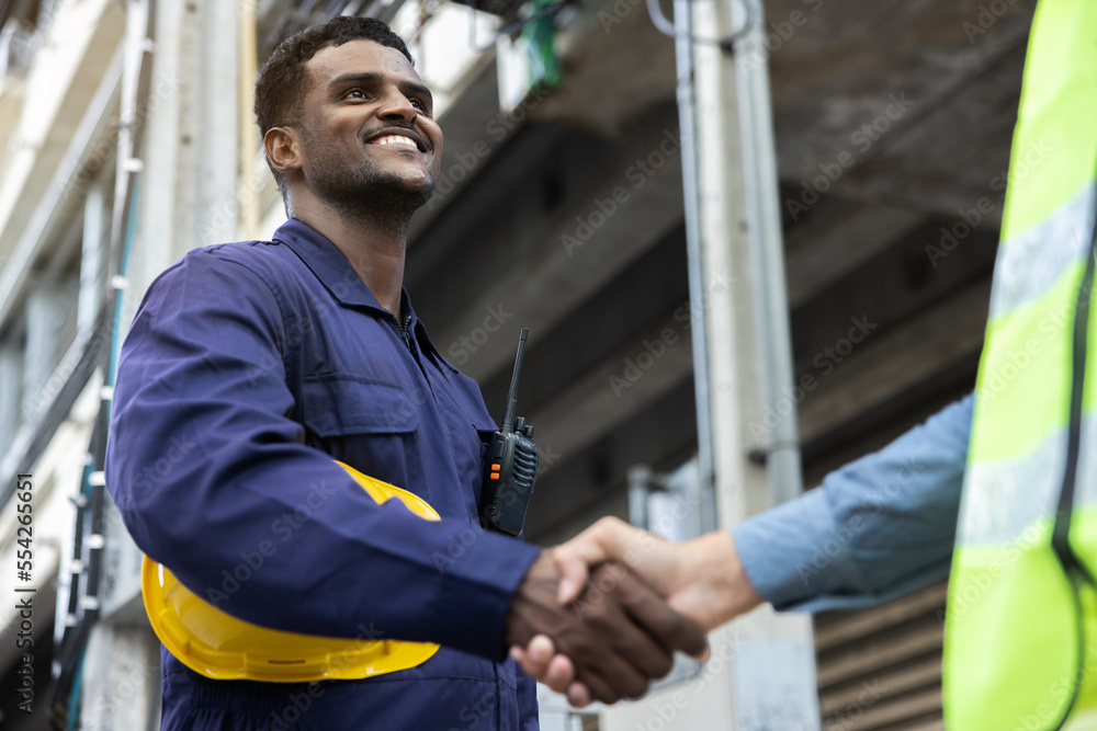 construction workers shaking hands together with co-workers ...