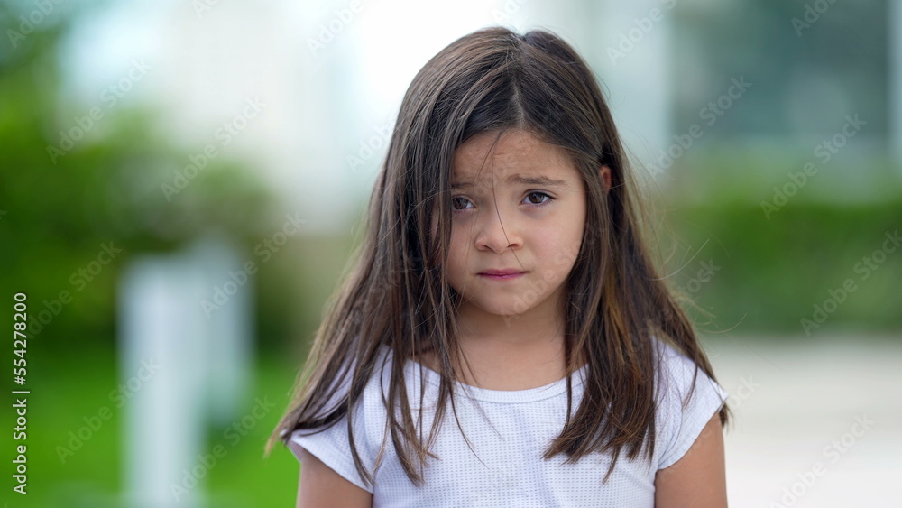Portrait little girl with concerned emotion nervous child looking at ...