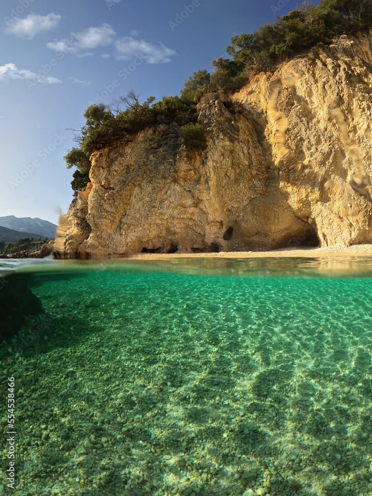 Underwater split photo of crystal clear emerald sea and small caves of ...