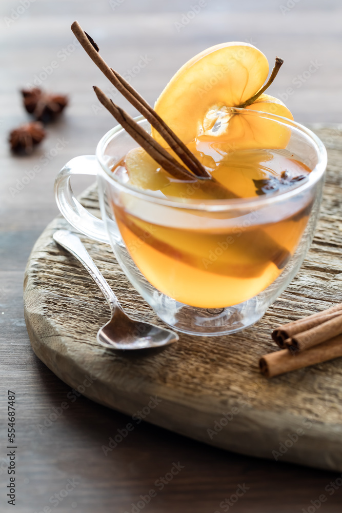 Homemade hot apple cider in a clear glass cup, with light coming from ...