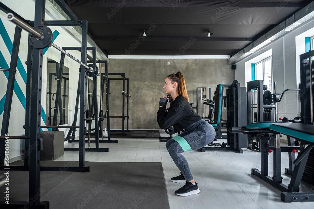 beautiful fitness lady working out in the gym doing exercises that pump ...
