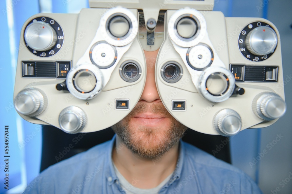 Adult man eyesight test with binocular slit-lamp. Checking retina of a ...