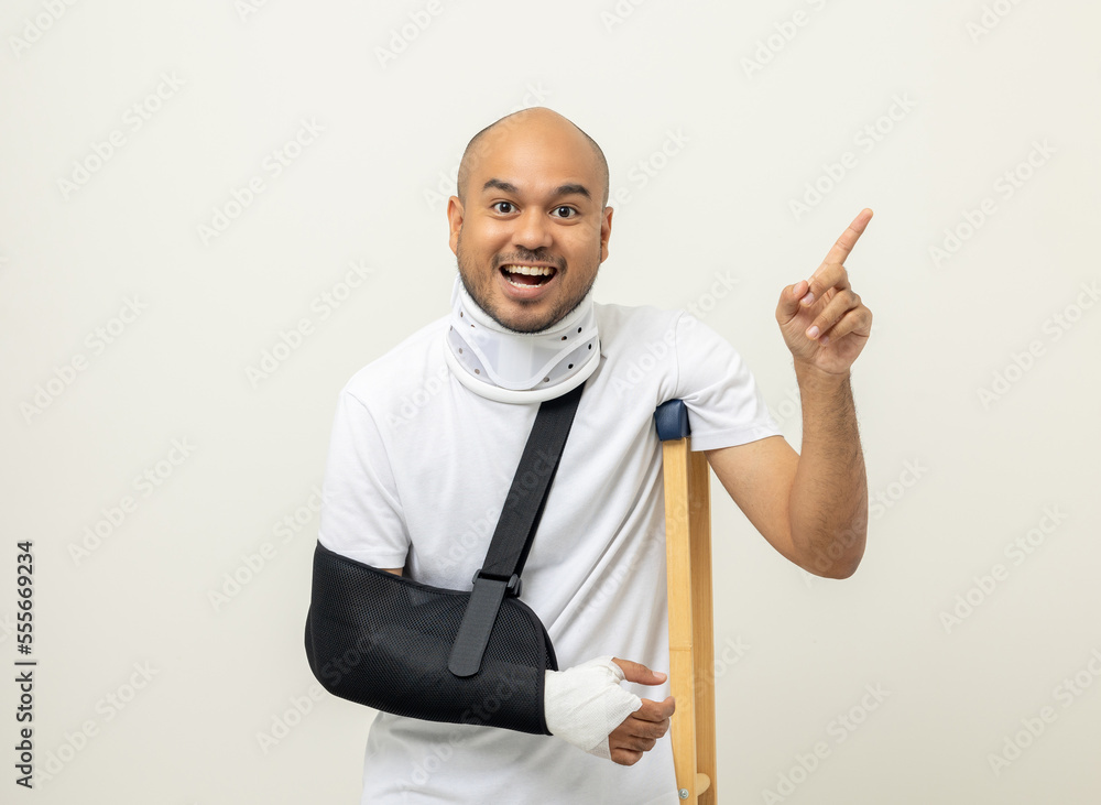 Shocked face man broken arm and leg pointing finger to blank space. Man ...