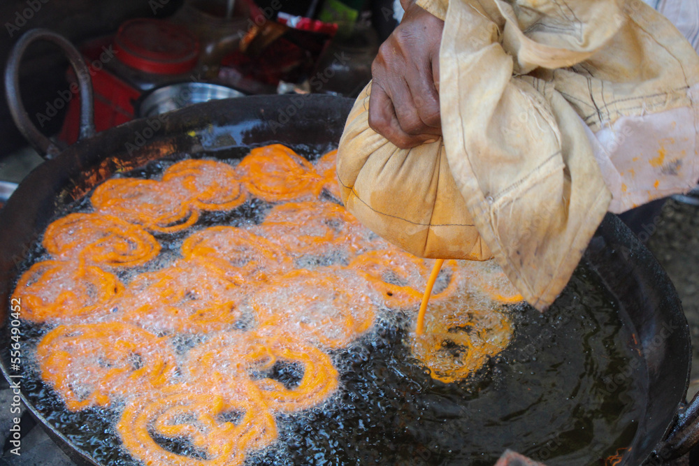 Indian male hand making Jalebi (traditional Indian fried sweet dessert ...