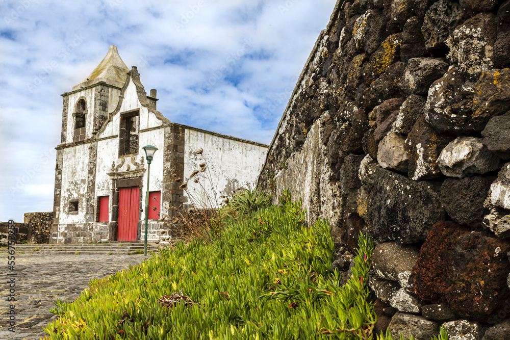 Old stone wall and the 16th century ruins of the Church of Sao Mateus ...