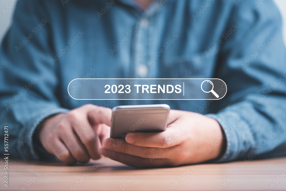 Businessman using smartphone to input keyword of 2023 trends inside ...