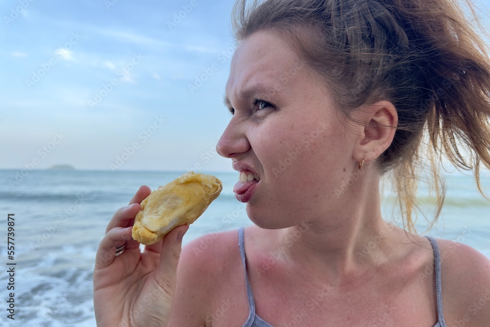 Young woman, beautiful girl is eating smelly stinky durian Asian exotic ...