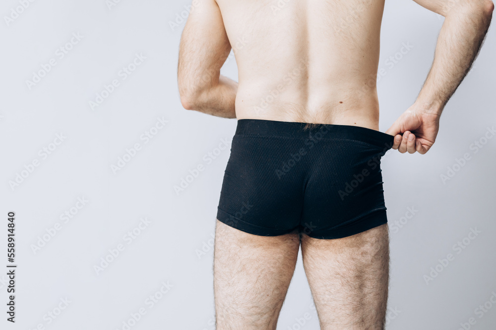 Beautiful male ass. The man is standing with his back to the camera. buttocks of a man in black ...