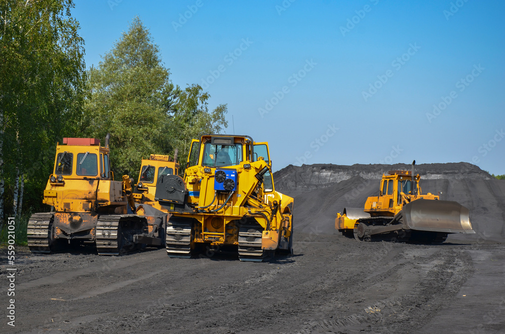 Foto de Stock Crawler dozers on a coal heap. Mining machines moving ...