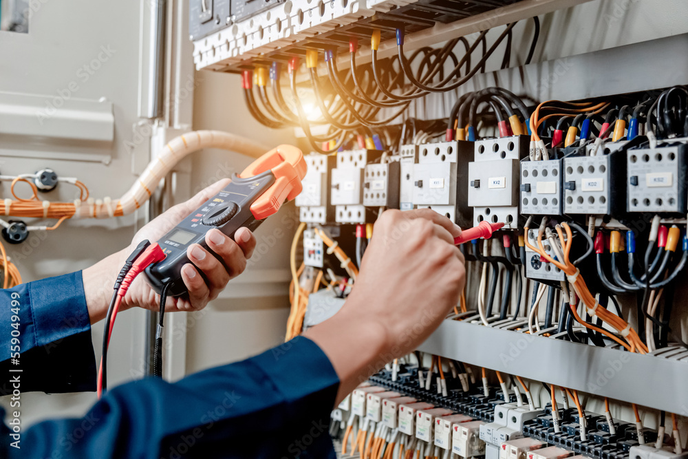 Electrician engineer uses a multimeter to test the electrical ...