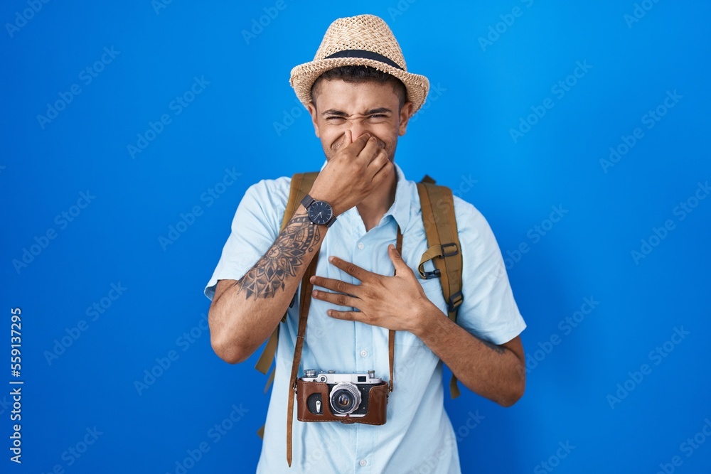 Brazilian young man holding vintage camera smelling something stinky ...