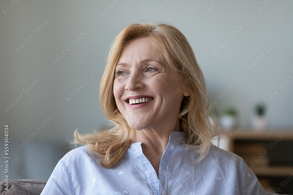 Cheerful attractive mature pensioner woman looking away, smiling at ...