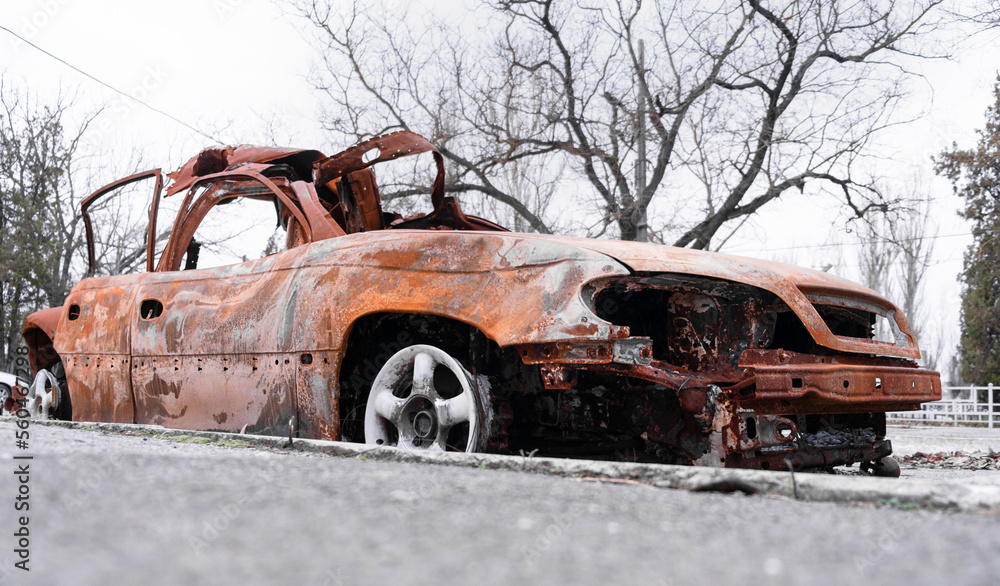 Burnt damaged car of a civilian during the war, Russian attack against Ukraine. War crimes of ...
