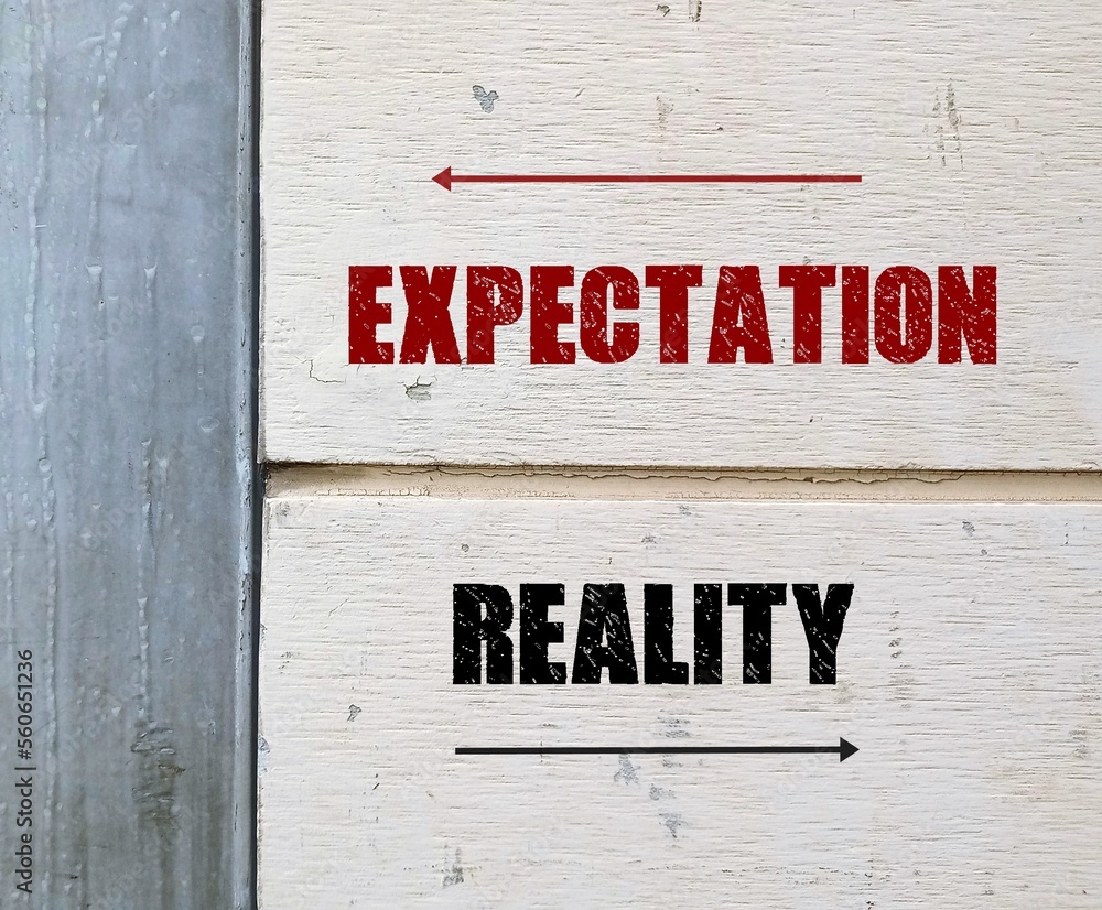 Wall with opposite direction sign written EXPECTATION and REALITY ...