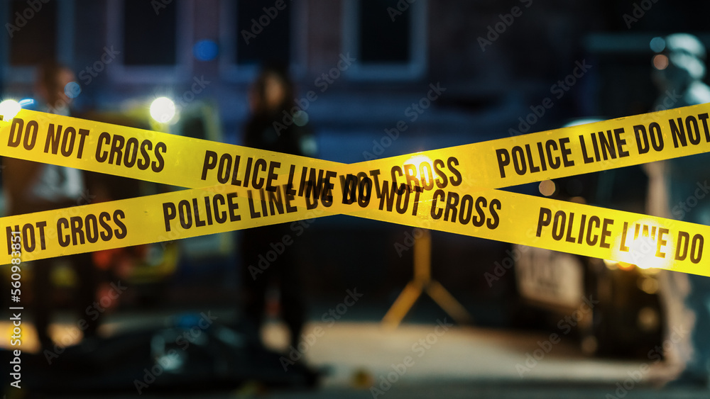 Restricted Area: Yellow Tape Showing Text "Police Line Do Not Cross". Blurred Background with ...