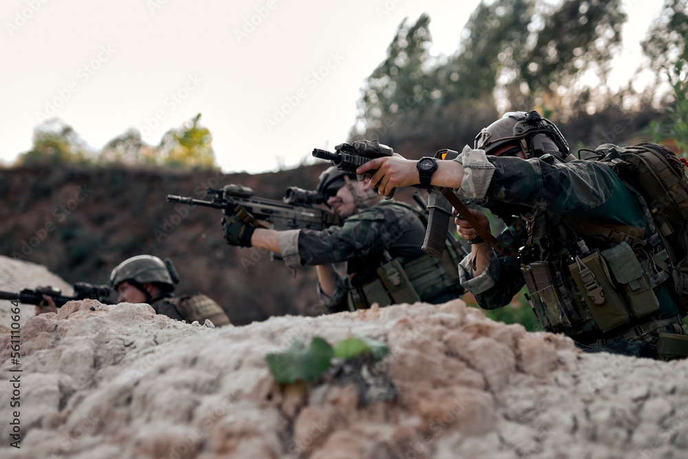 team of army soldiers, shooters wearing combat uniform, body armor and ...