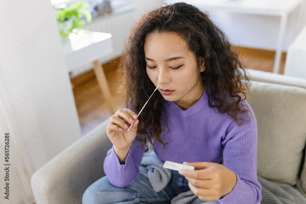 Asian woman using cotton swab while doing coronavirus PCR test. Woman ...