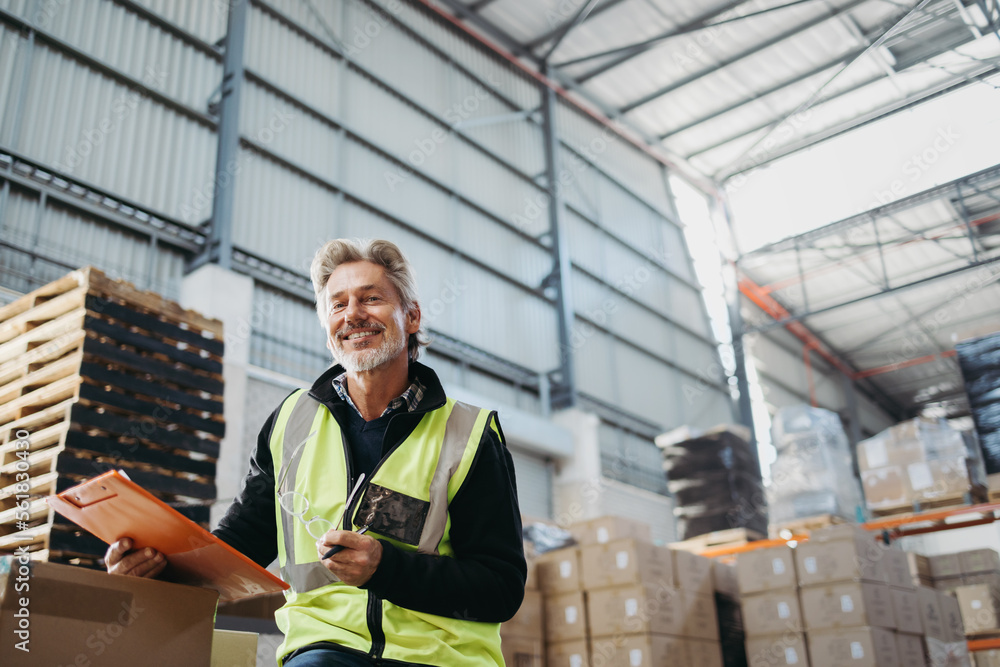 Happy senior man working in a distribution warehouse Stock Photo ...