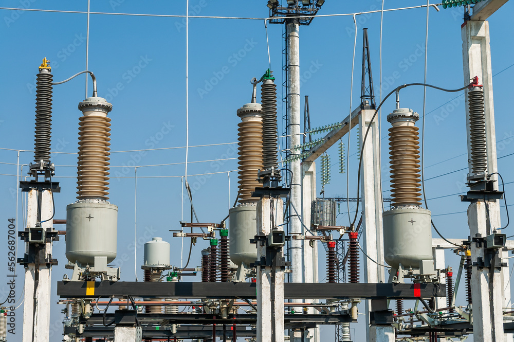 Part of high-voltage substation on blue sky background with switches ...