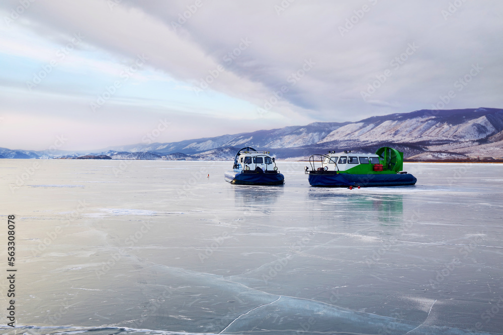 Hovercraft on transparent ice with cracks of frozen Lake Baikal. Khivus ...