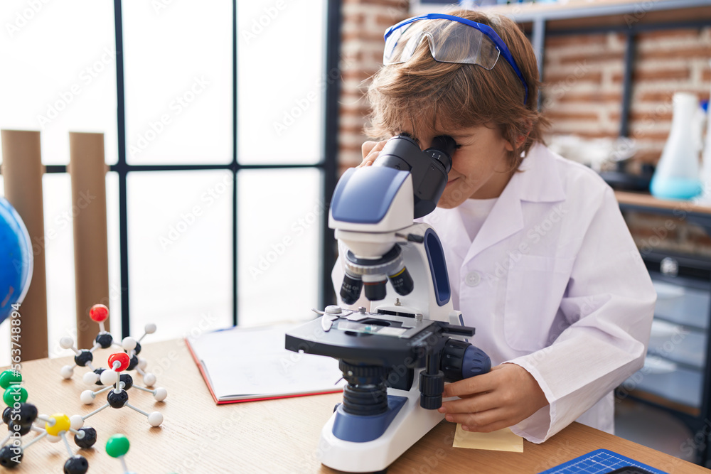 Adorable caucasian boy student using microscope at classroom Stock ...