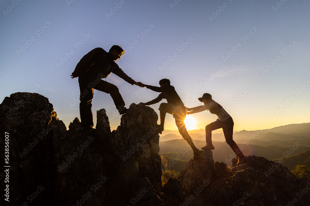 silhouette of Teamwork of three hiker helping each other on top of mountain climbing team ...