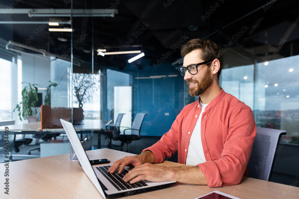 Successful smiling man working inside office with laptop, businessman ...