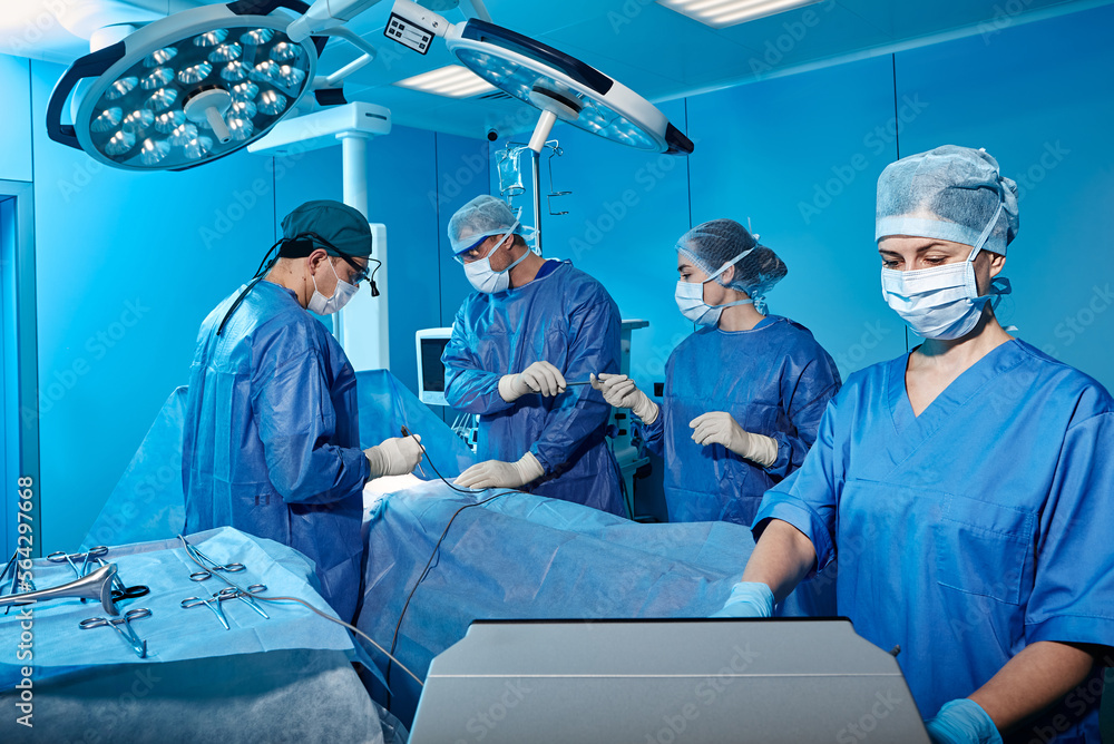Hospital operating theatre with medical team wearing personal ...