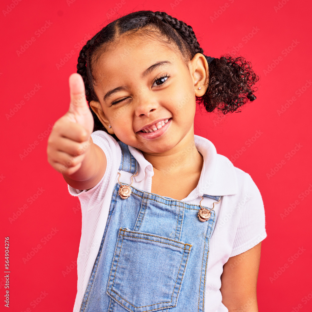 Thumbs up, portrait and girl child in studio, red background or ...
