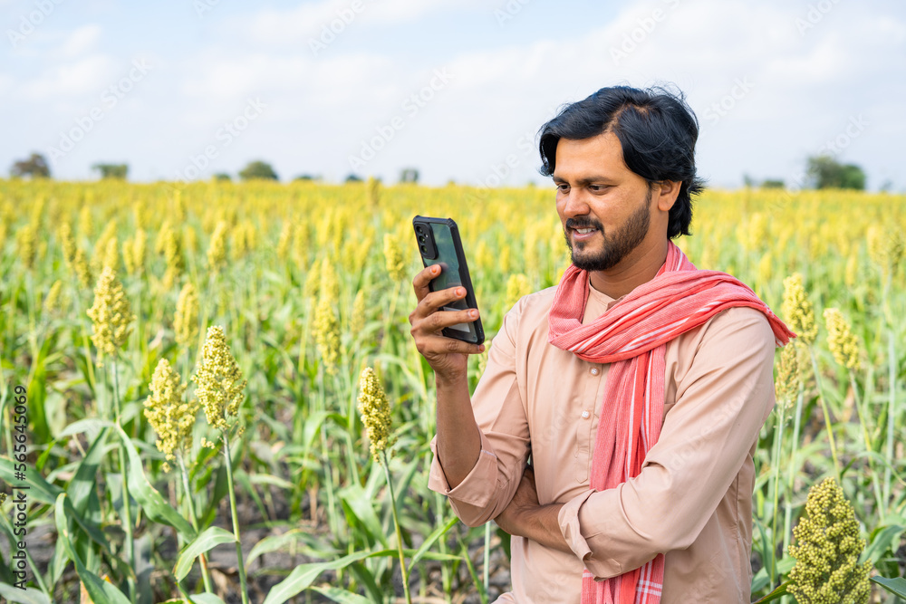 Farmer busy using mobile phone at agricultural farm land showing with ...