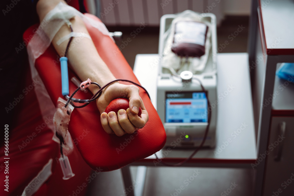 The hand of a man who donates blood. Male donor gives blood in a blood ...