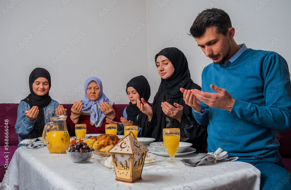 Muslim family making iftar dua to break fasting during Ramadan happy ...