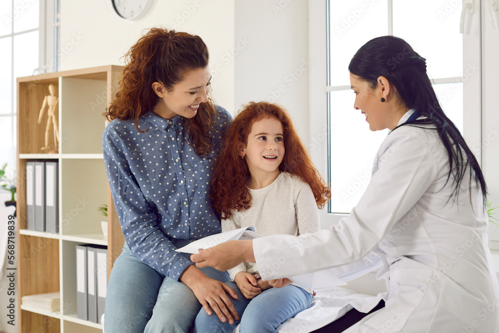 Cute little preteen girl with smiling mom at reception in pediatrician ...