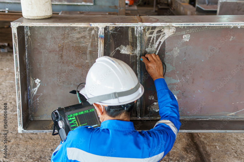 Inspectors are checking defects in welded steel h-beam add joint with ...