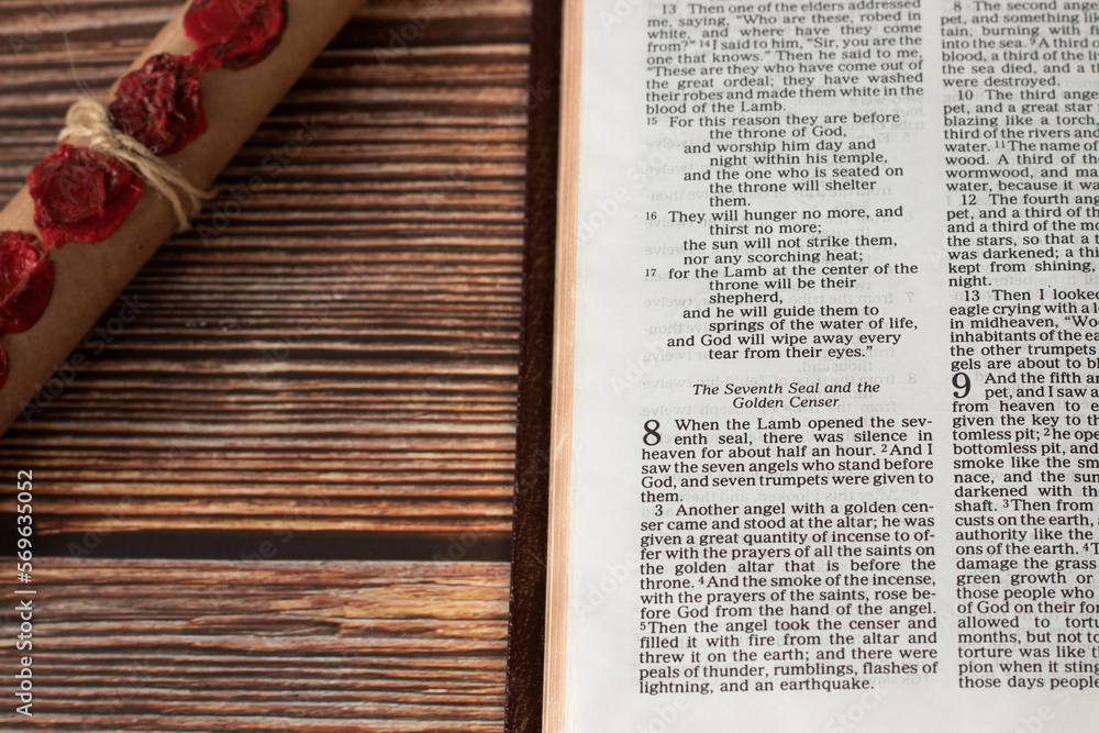 Revelation 8, open holy bible book on wooden table and old paper scroll ...
