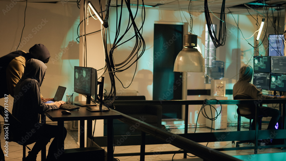 Fotografie Web criminals making online threats stealing information on multi monitors, breaking ...