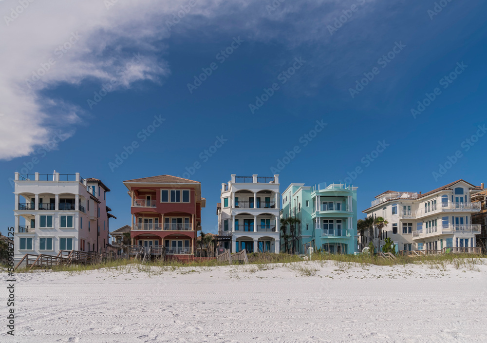 Beach houses facade with balconies and roof decks facing the white sand ...